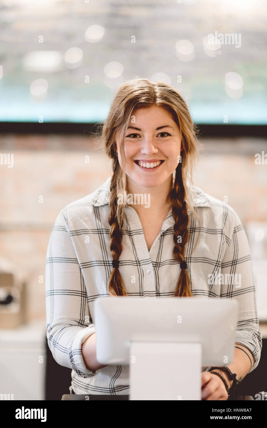 Cashier behind cash register in cafe Stock Photo - Alamy