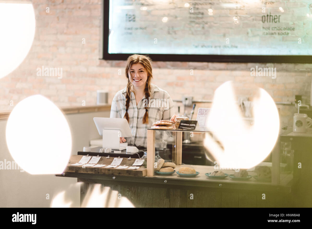Cashier behind cash register in cafe Stock Photo - Alamy
