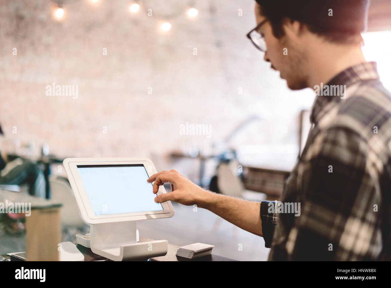 Cashier using cash register in cafe Stock Photo - Alamy