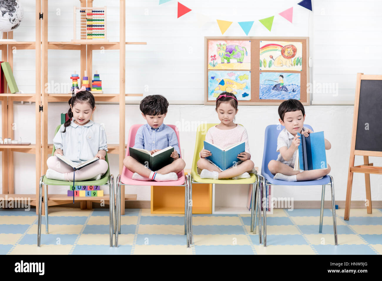 Kindergarten children reading books Stock Photo - Alamy