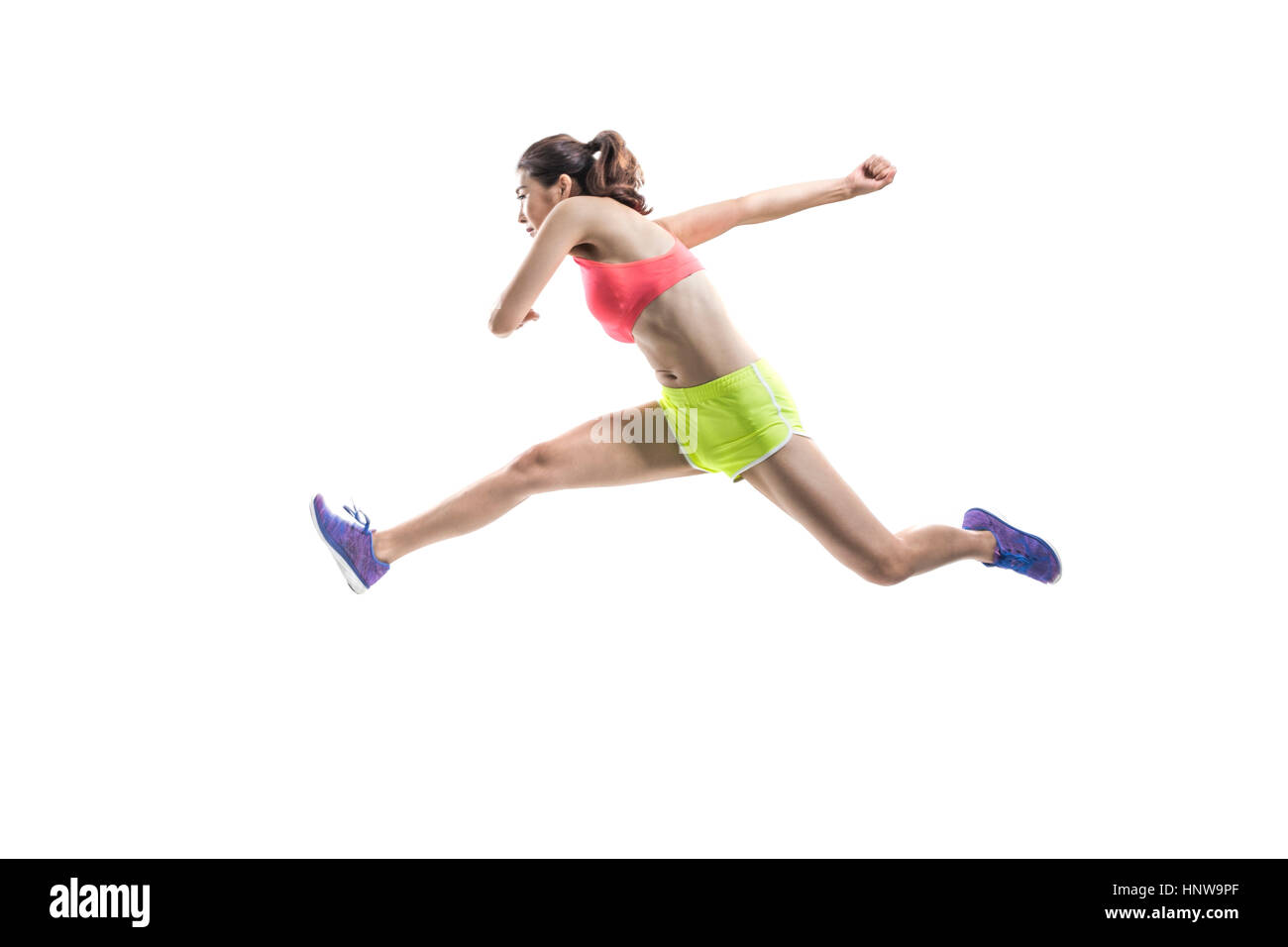 Side view of female athlete jumping Stock Photo - Alamy