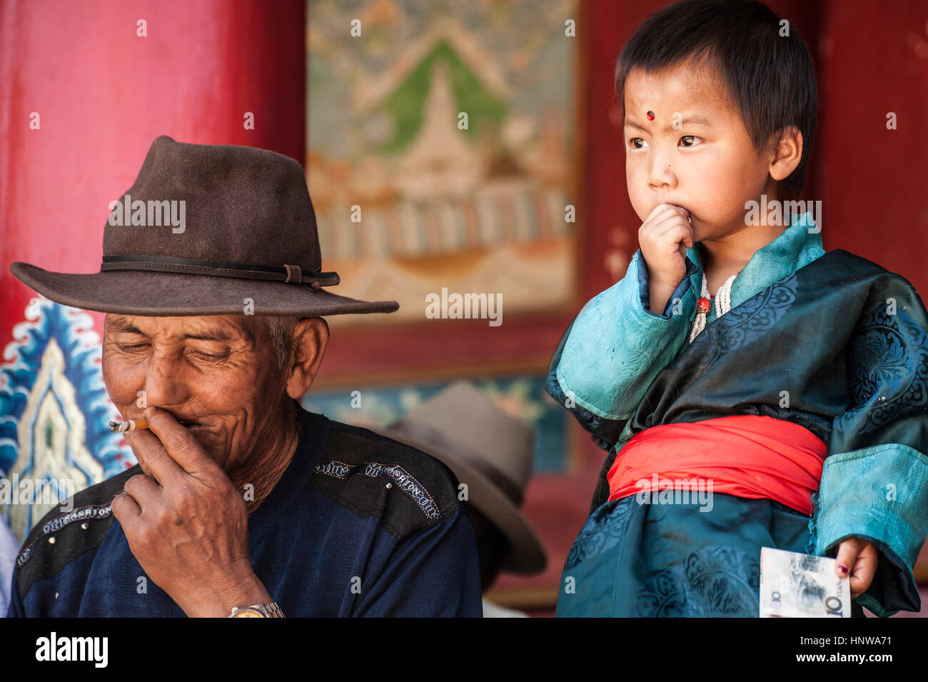 Young boy seemingly mimicking an old man smoking, Amdo Tibetan China ...
