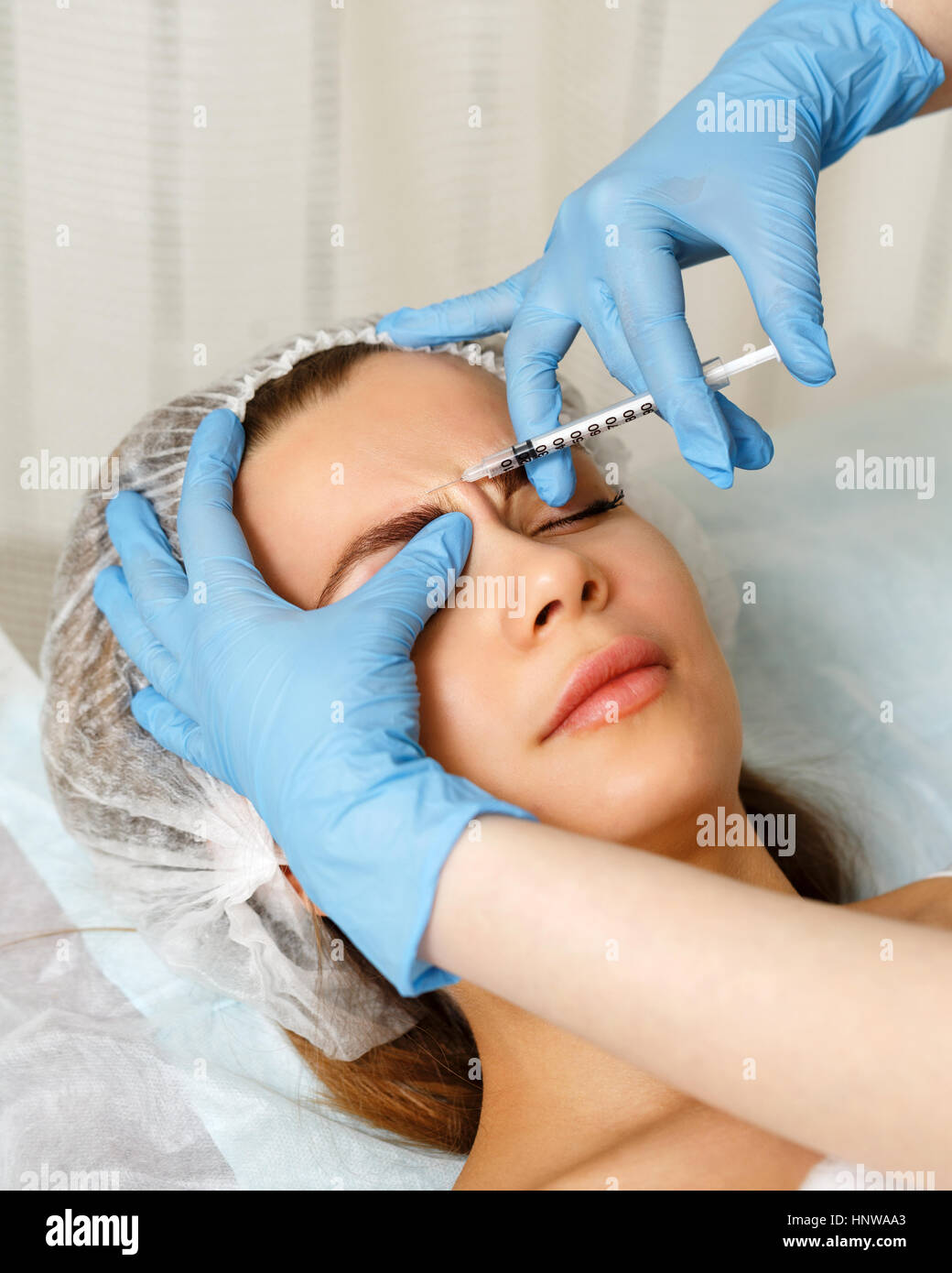 Injections under the skin. Prick over her eyebrow. Injection of beauty ...