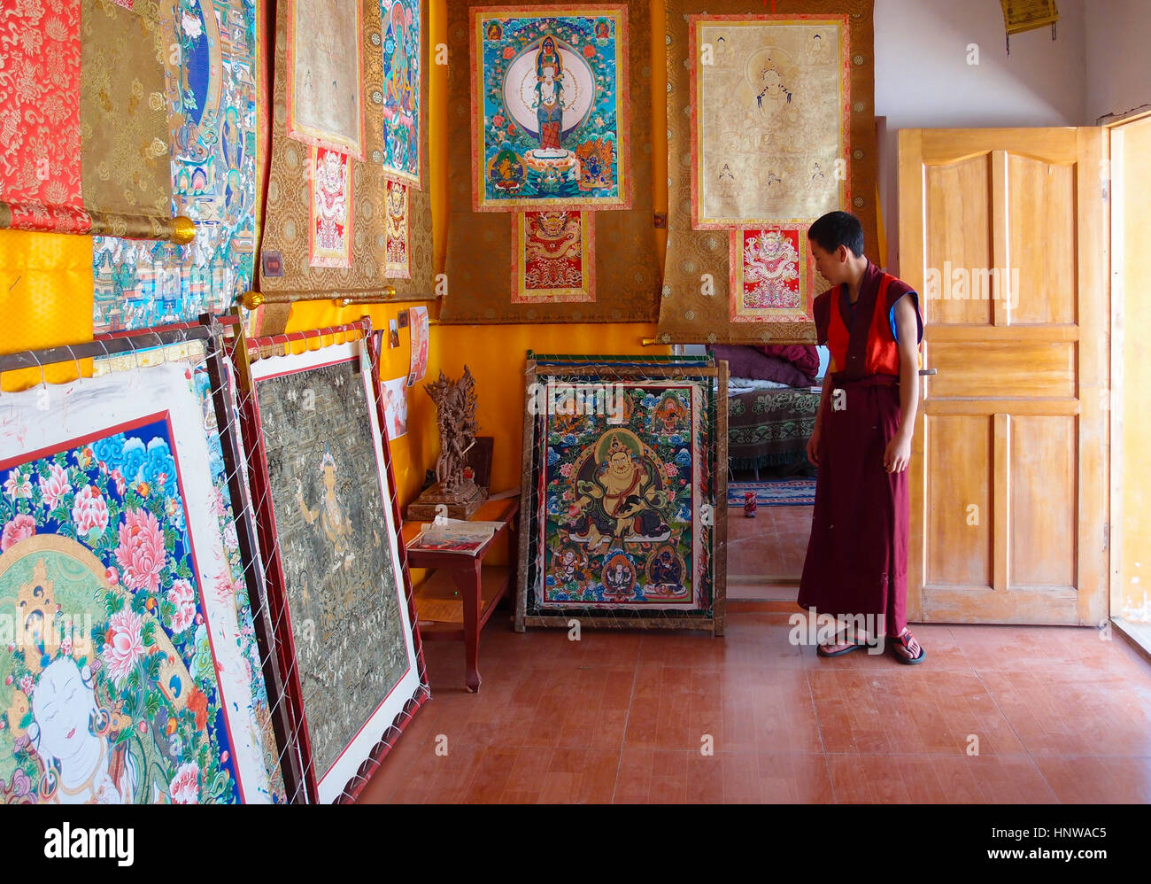 A young monk standing in a room full of thangka Stock Photo - Alamy