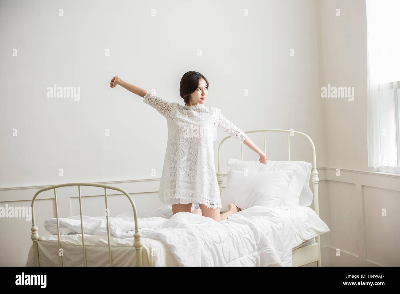 Young woman stretching in bed Stock Photo - Alamy