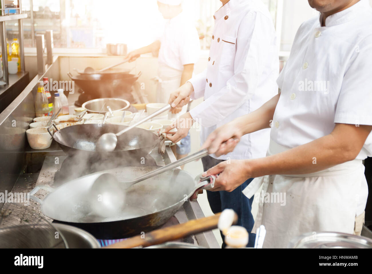 Group of chefs in hotel or restaurant kitchen busy cooking Stock Photo ...