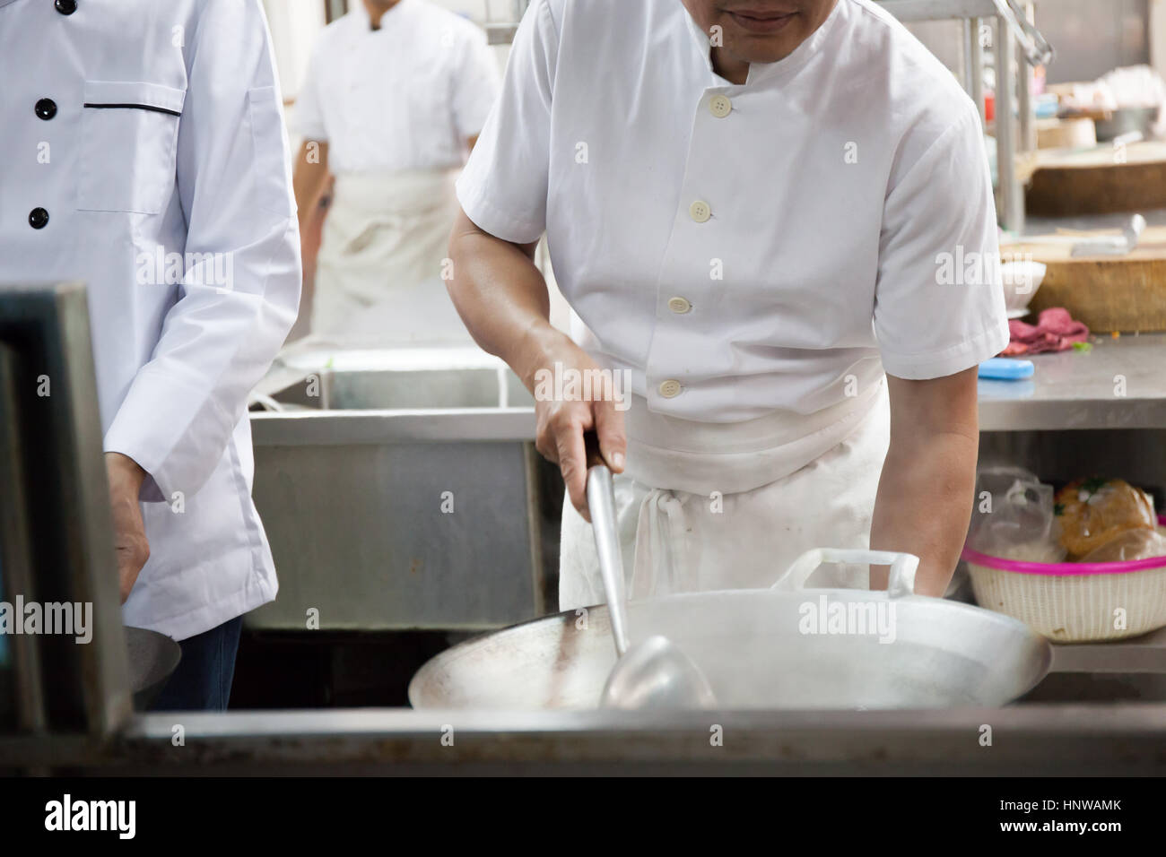 Group of chefs in hotel or restaurant kitchen busy cooking Stock Photo ...