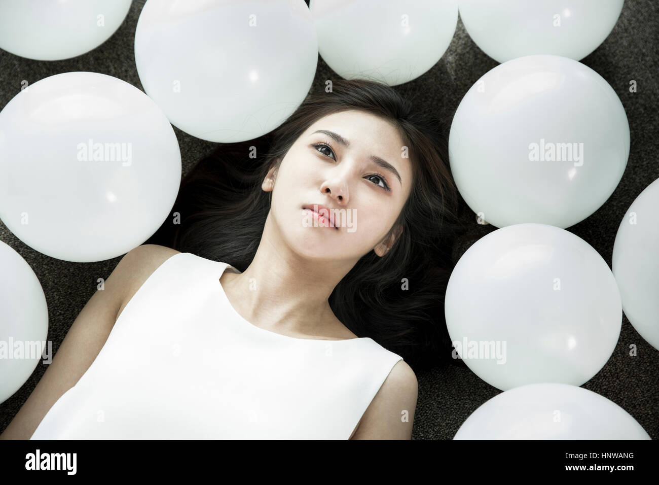 Portrait of young woman with white balloons Stock Photo - Alamy