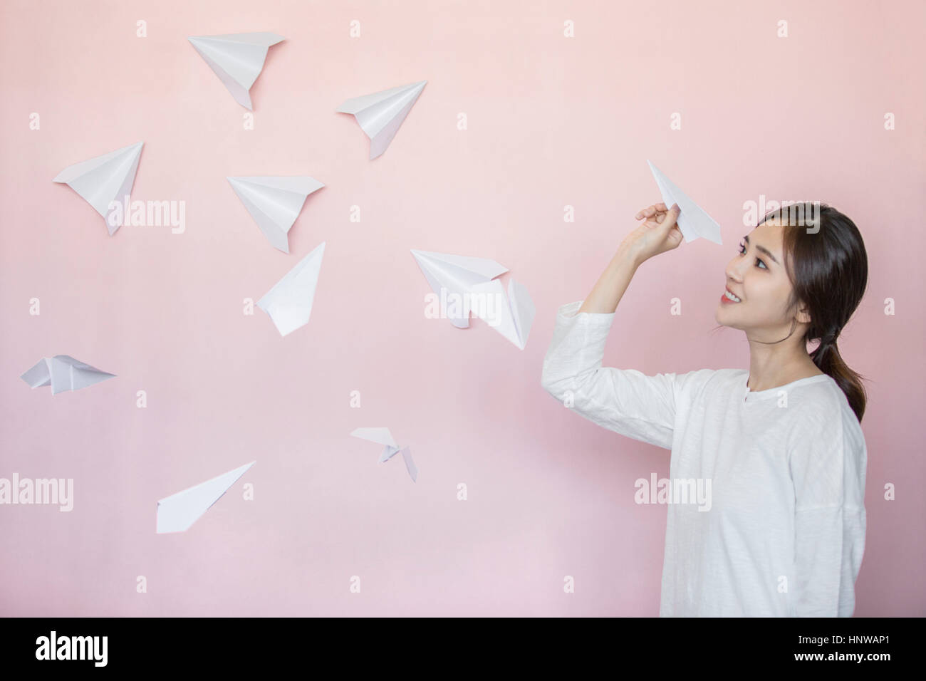 Young woman with white paper airplanes Stock Photo - Alamy