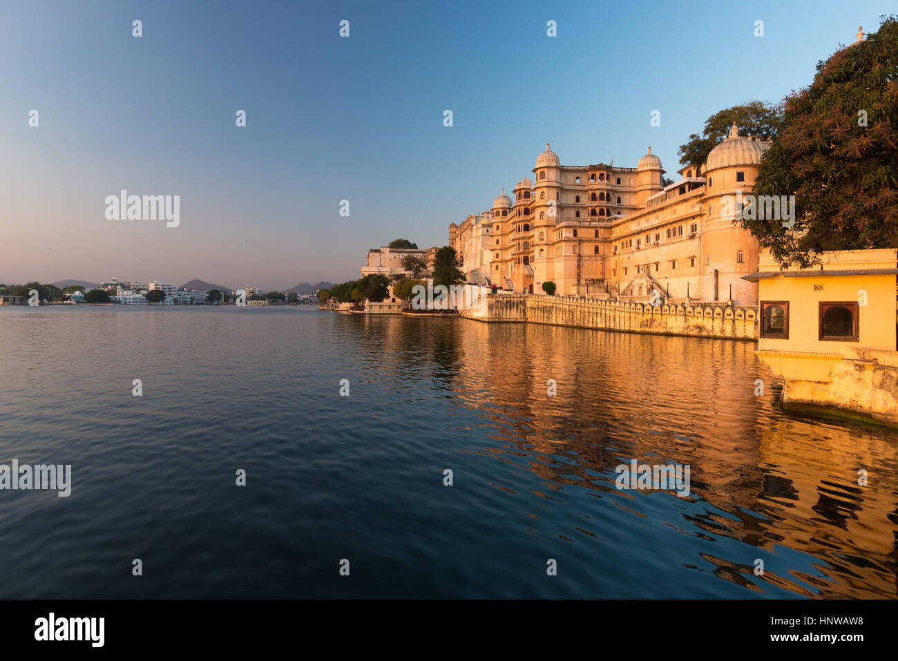Udaipur cityscape at sunset. The majestic city palace on Lake Pichola ...