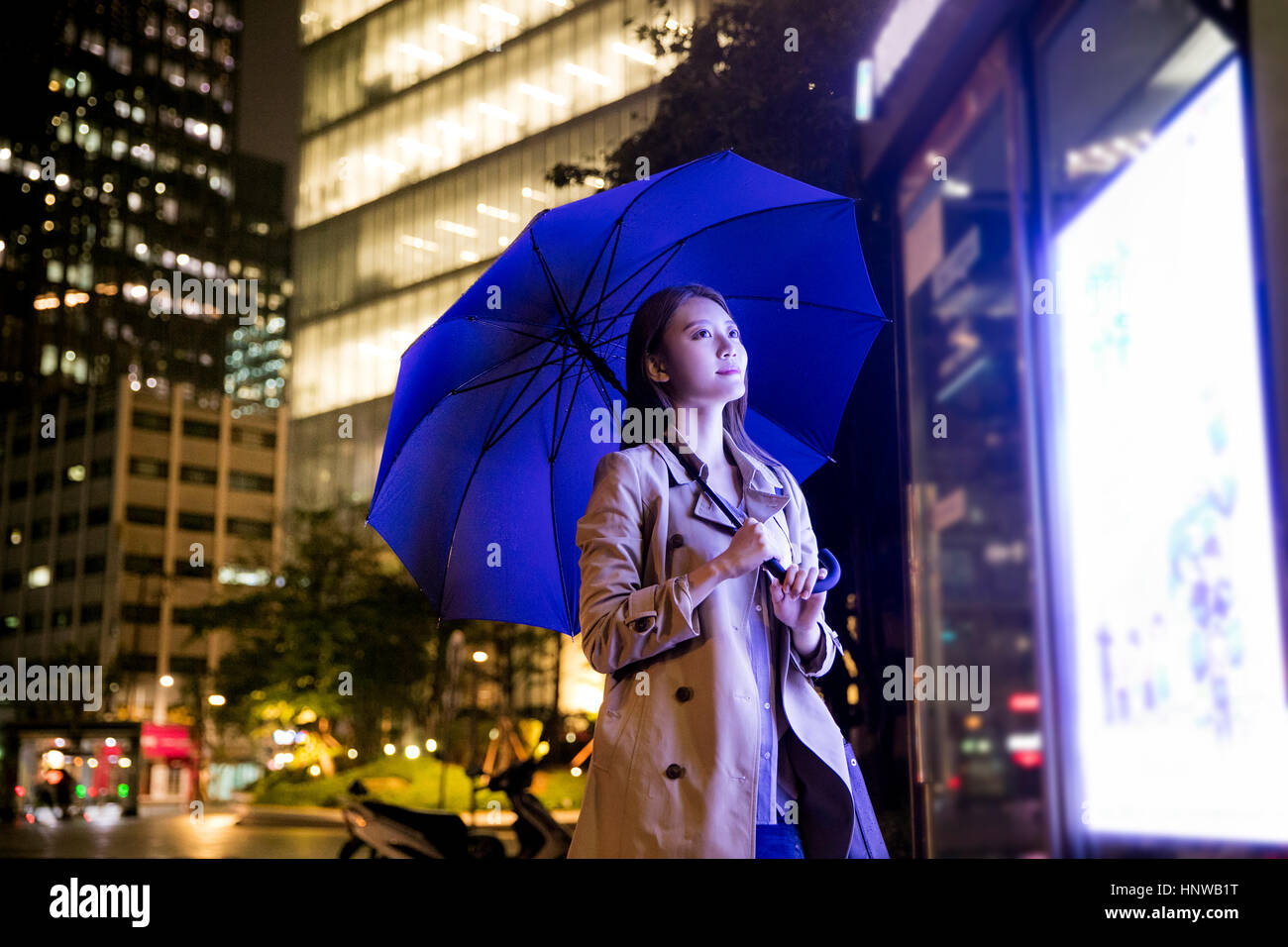 Smiling woman with umbrella at night Stock Photo - Alamy