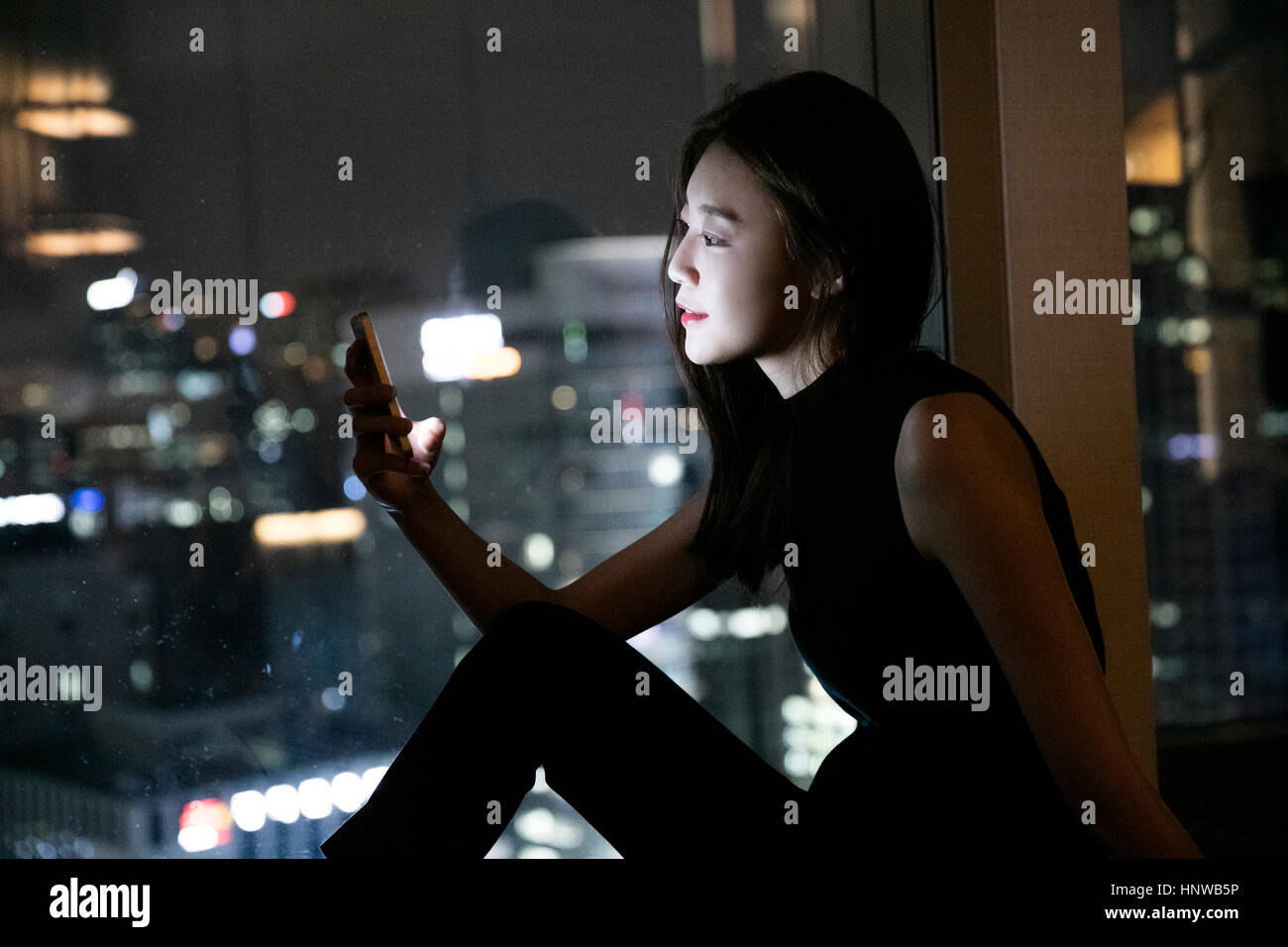 Young woman sitting using smartphone hi-res stock photography and ...