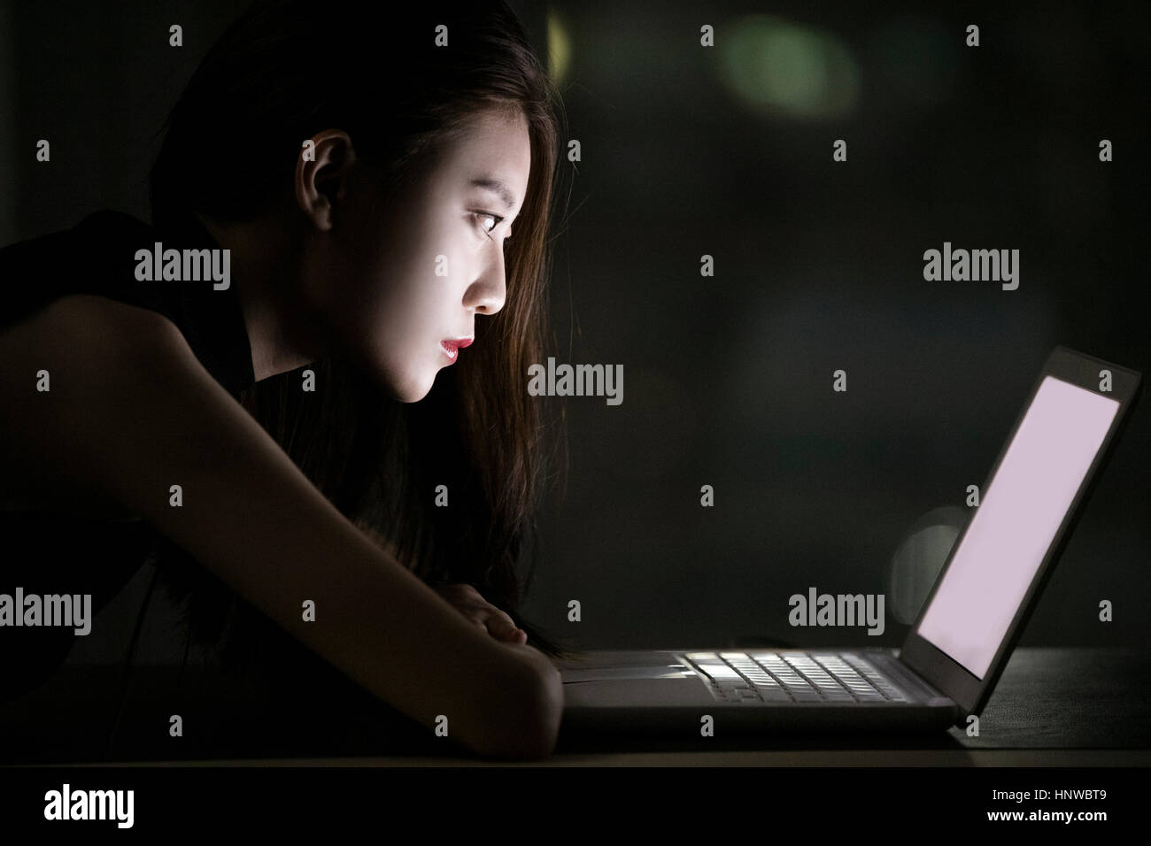 Woman using notebook computer at night Stock Photo - Alamy