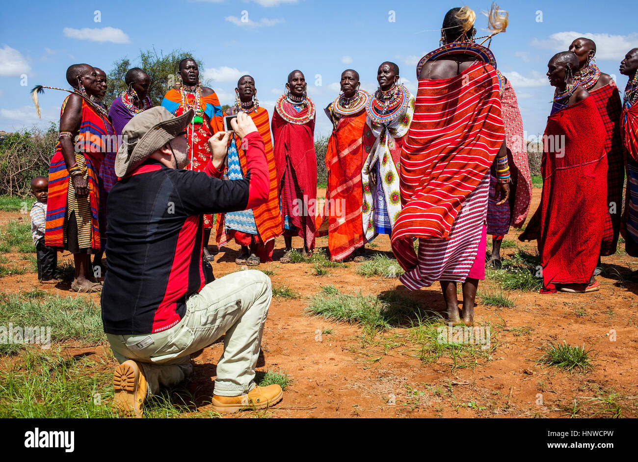 Tourist. Photographer taking pictures,A group of Masai women dancing a ...