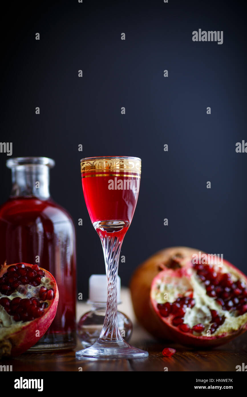 sweet pomegranate fruit alcoholic cordial in the decanter with a glass ...