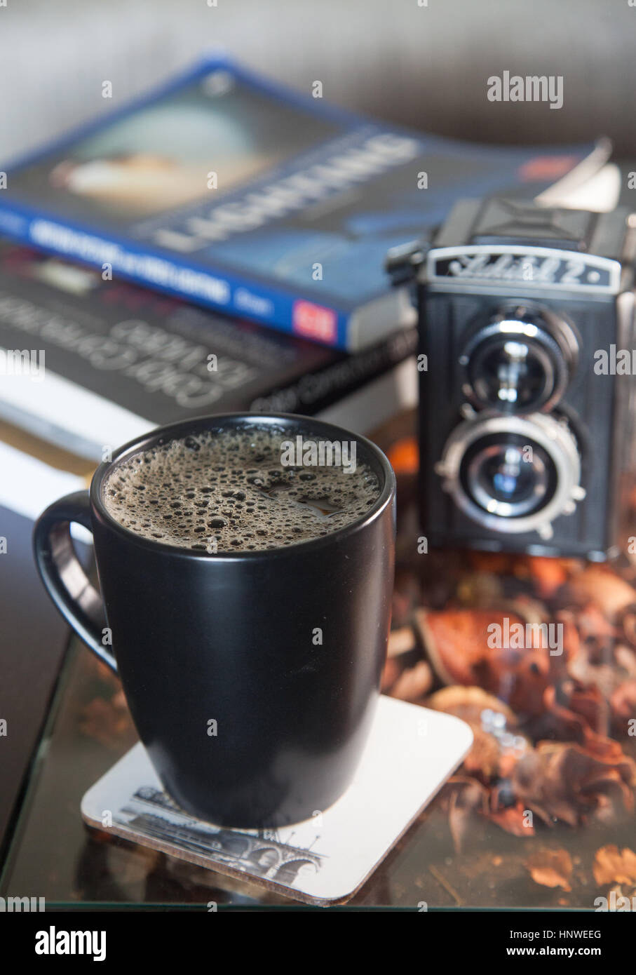 Coffee with film camera and pile of books Stock Photo - Alamy