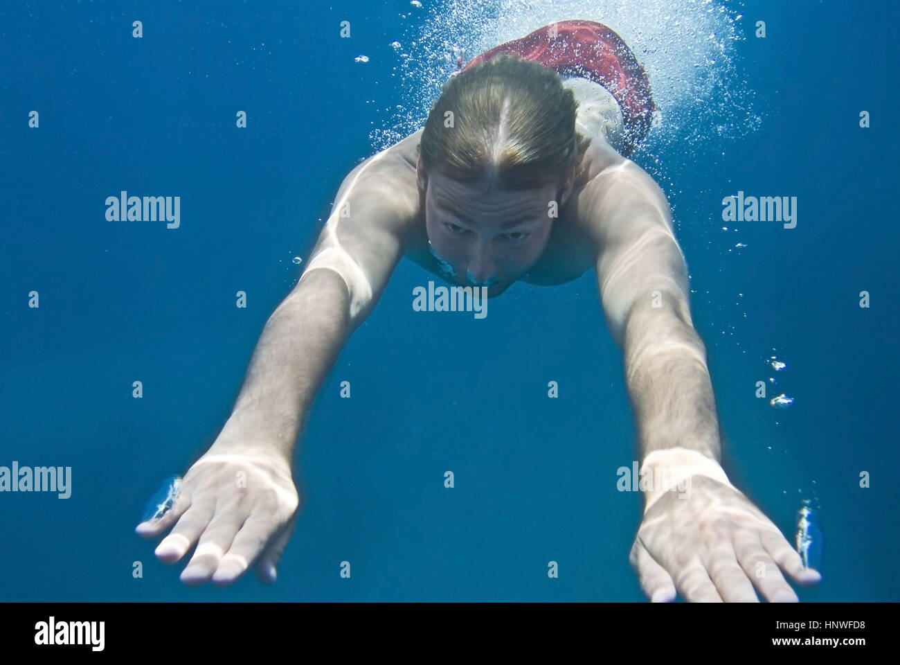 Model release, Mann schwimmt unter Wasser - man swimming under water ...