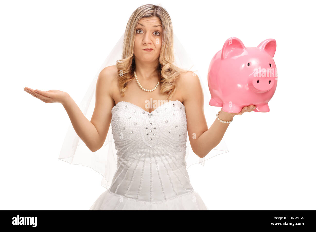 Upset bride holding a piggybank and gesturing with her hand isolated on ...