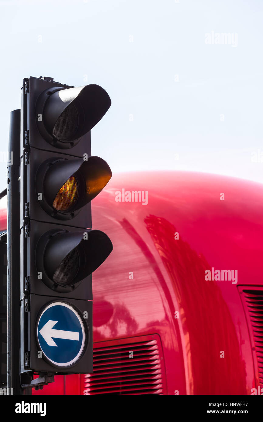 Traffic light with illuminated yellow signal lamp and white arrow on ...