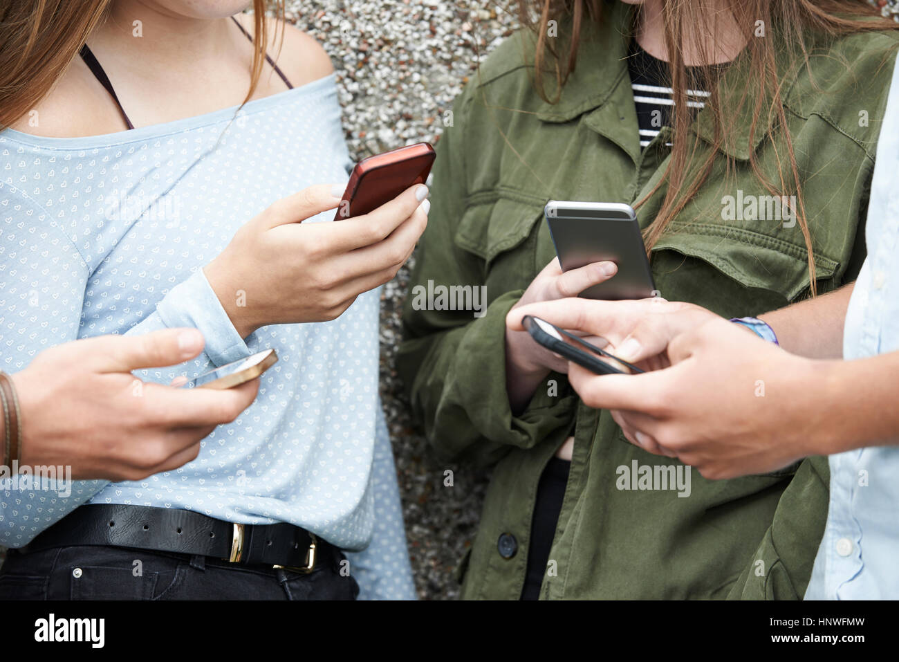 Group Of Teenagers Sharing Text Message On Mobile Phones Stock Photo ...