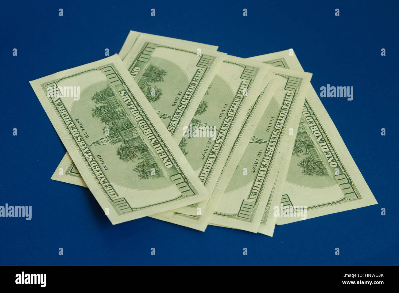Hundred dollar bills on dark blue background Stock Photo - Alamy