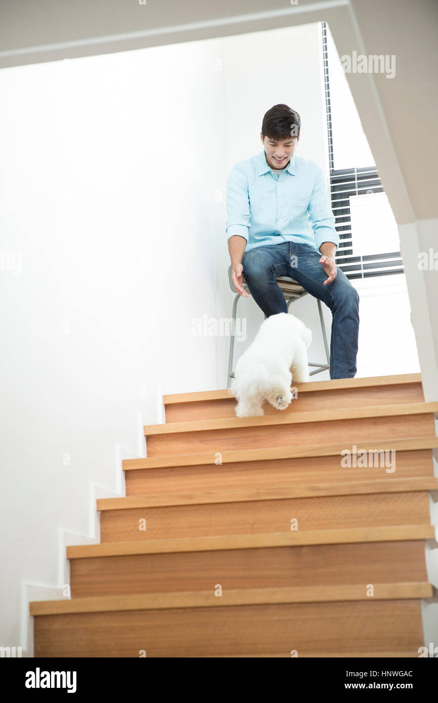 Smiling man calling his pet dog Stock Photo - Alamy