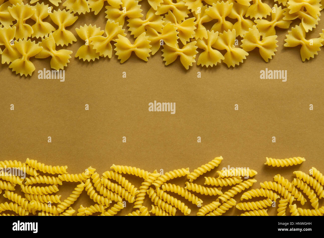 Pasta bow and spiral shape on brown background Stock Photo - Alamy