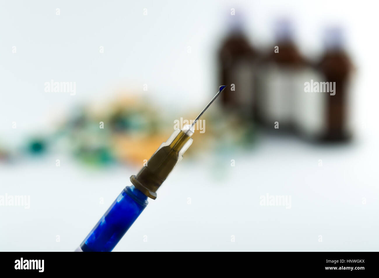 photo of injection. syringe with liquid drop on its needle,nozzle over ...