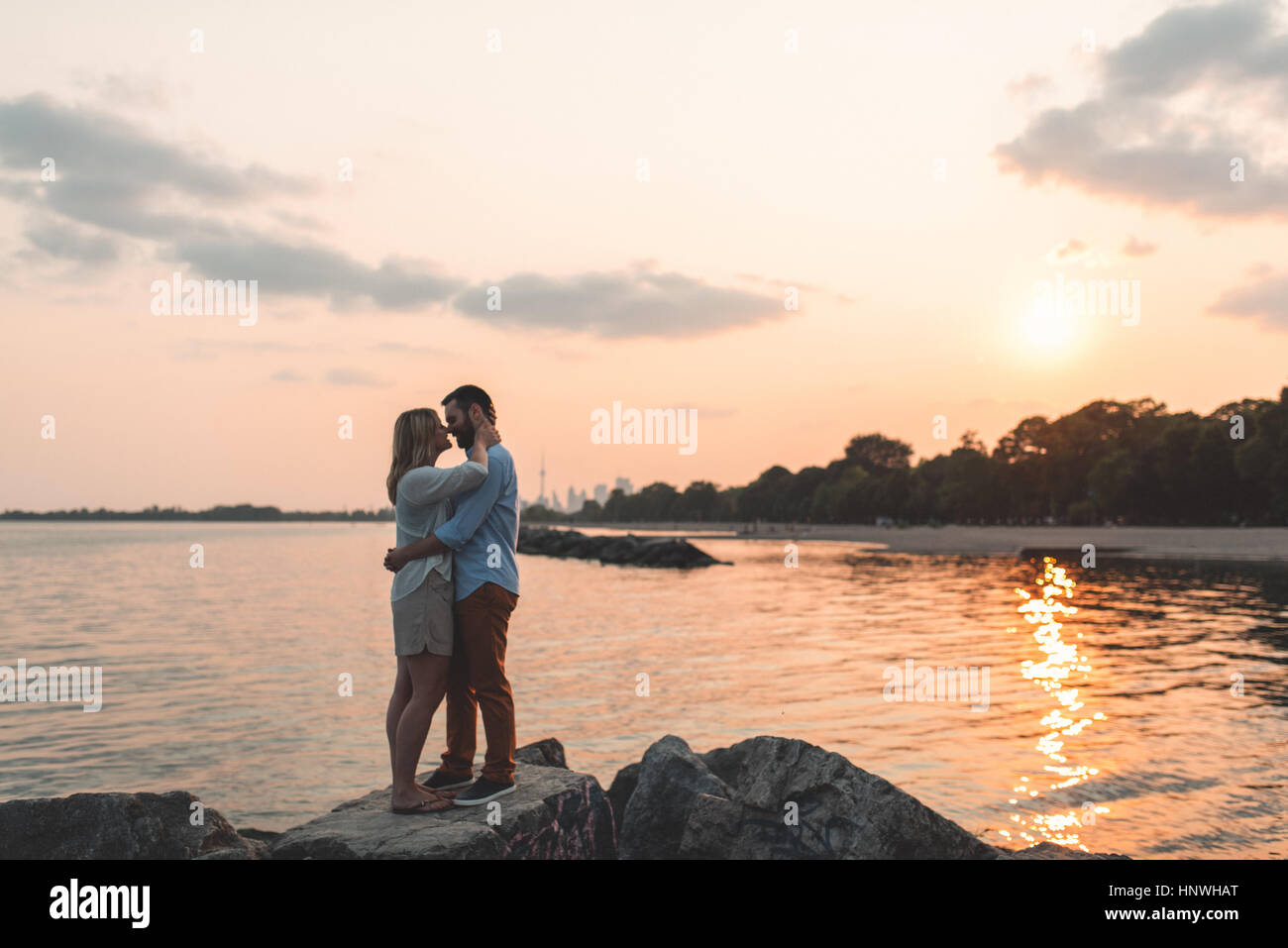 Romantic couple face to face on boulder, Lake Ontario, Toronto, Canada ...