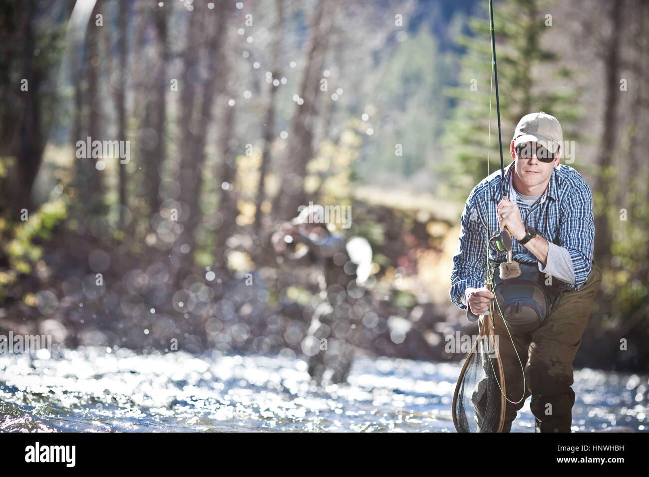 Fishermen ankle deep in river fly fishing, Colorado, USA Stock Photo ...