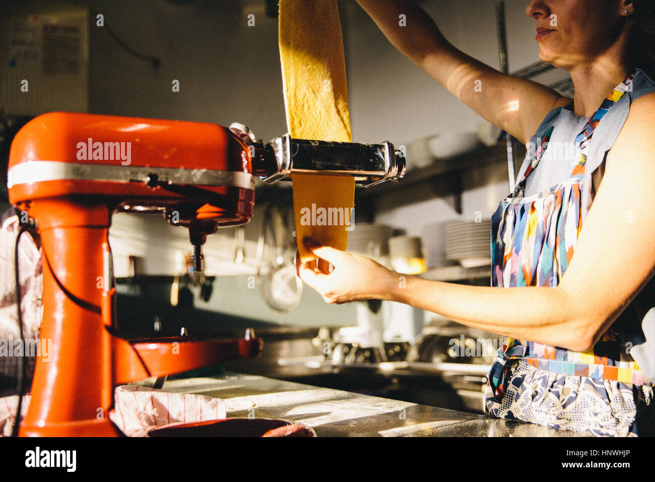 Woman flattening dough with pasta maker Stock Photo - Alamy