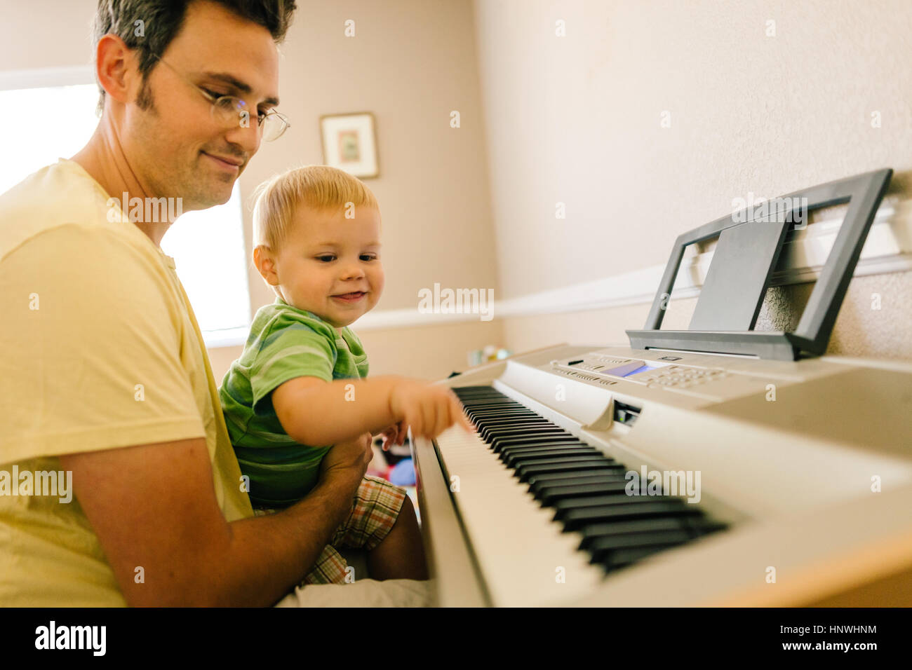 Father and young son playing musical keyboard together Stock Photo - Alamy