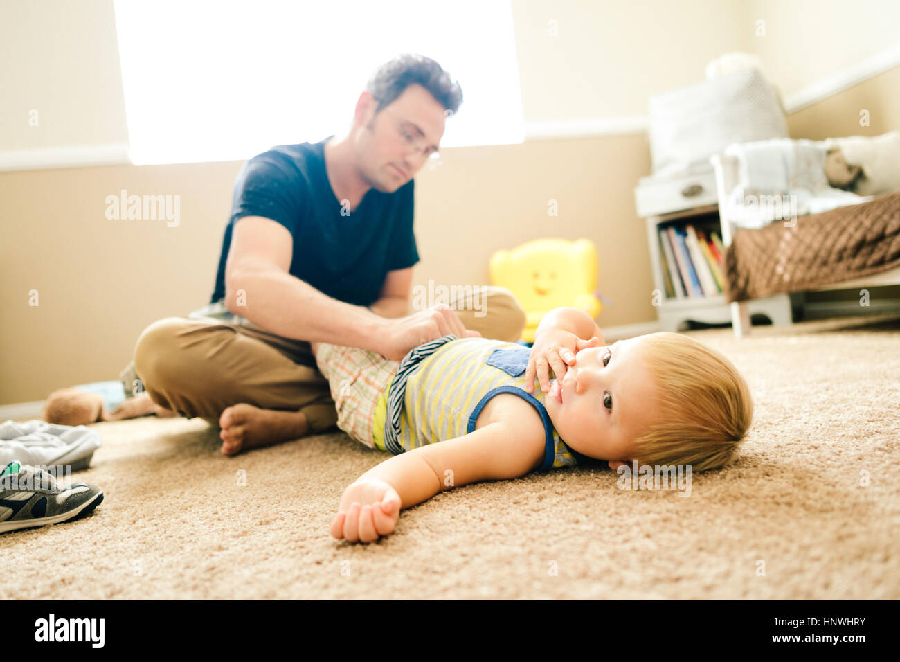 Father dressing young son Stock Photo - Alamy