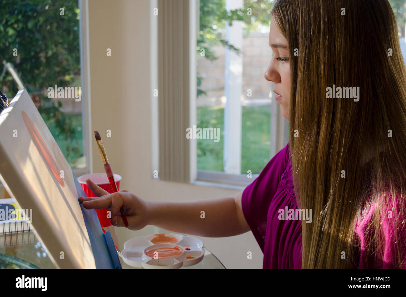 Teenage female artist painting on canvas in conservatory Stock Photo ...