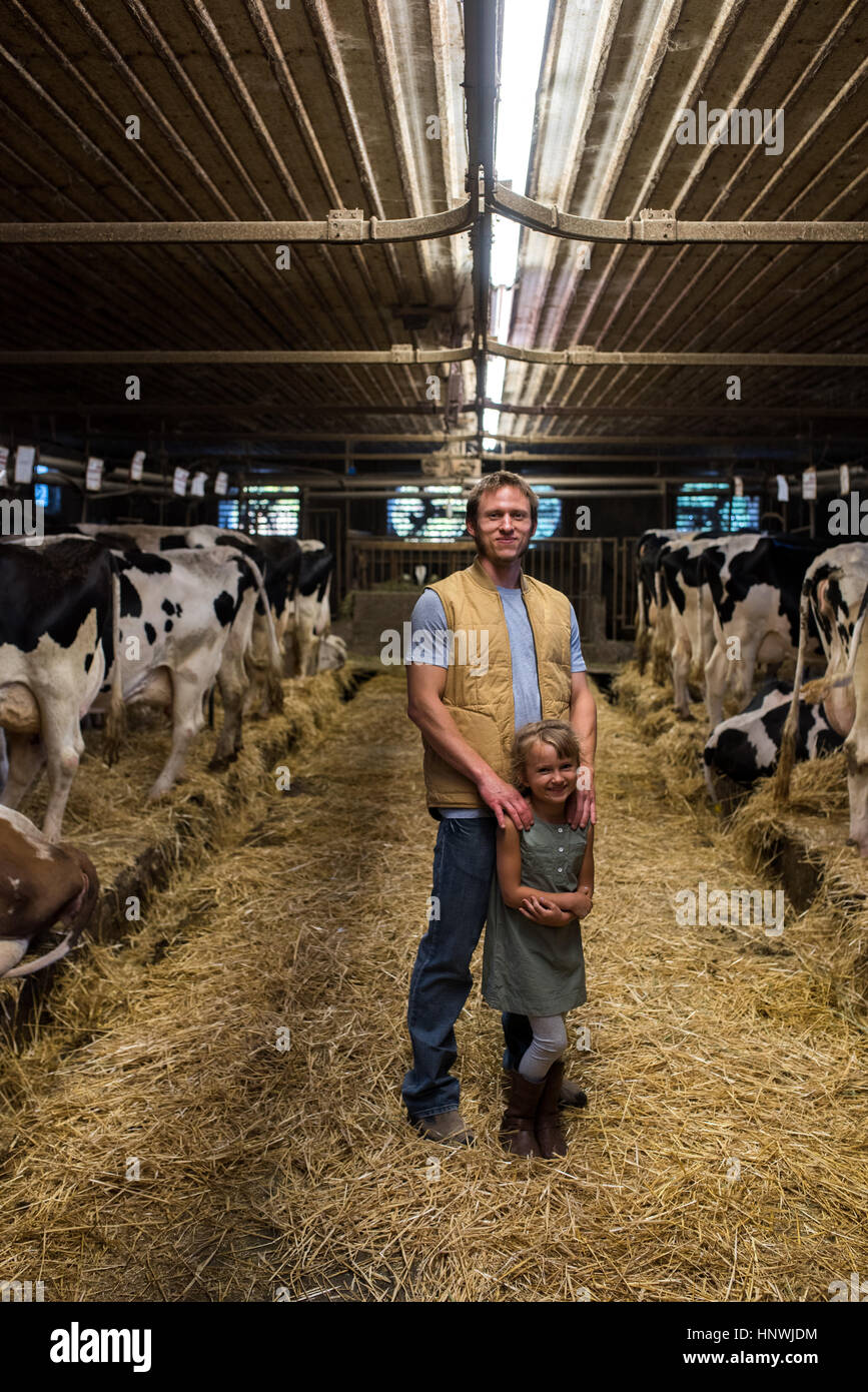 Portrait of farmer and daughter in cow shed Stock Photo - Alamy