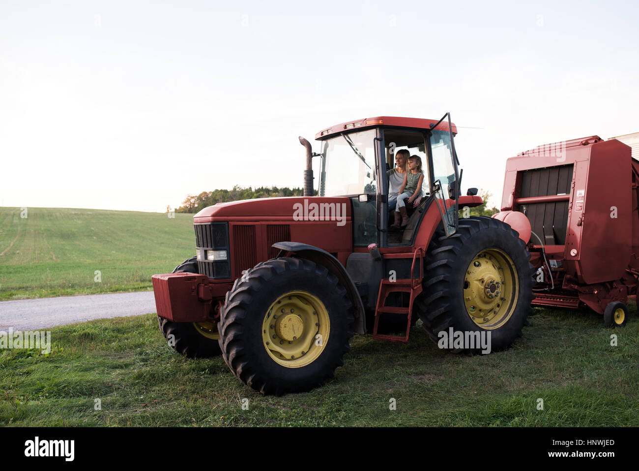 Mother and daughter sitting in tractor Stock Photo - Alamy