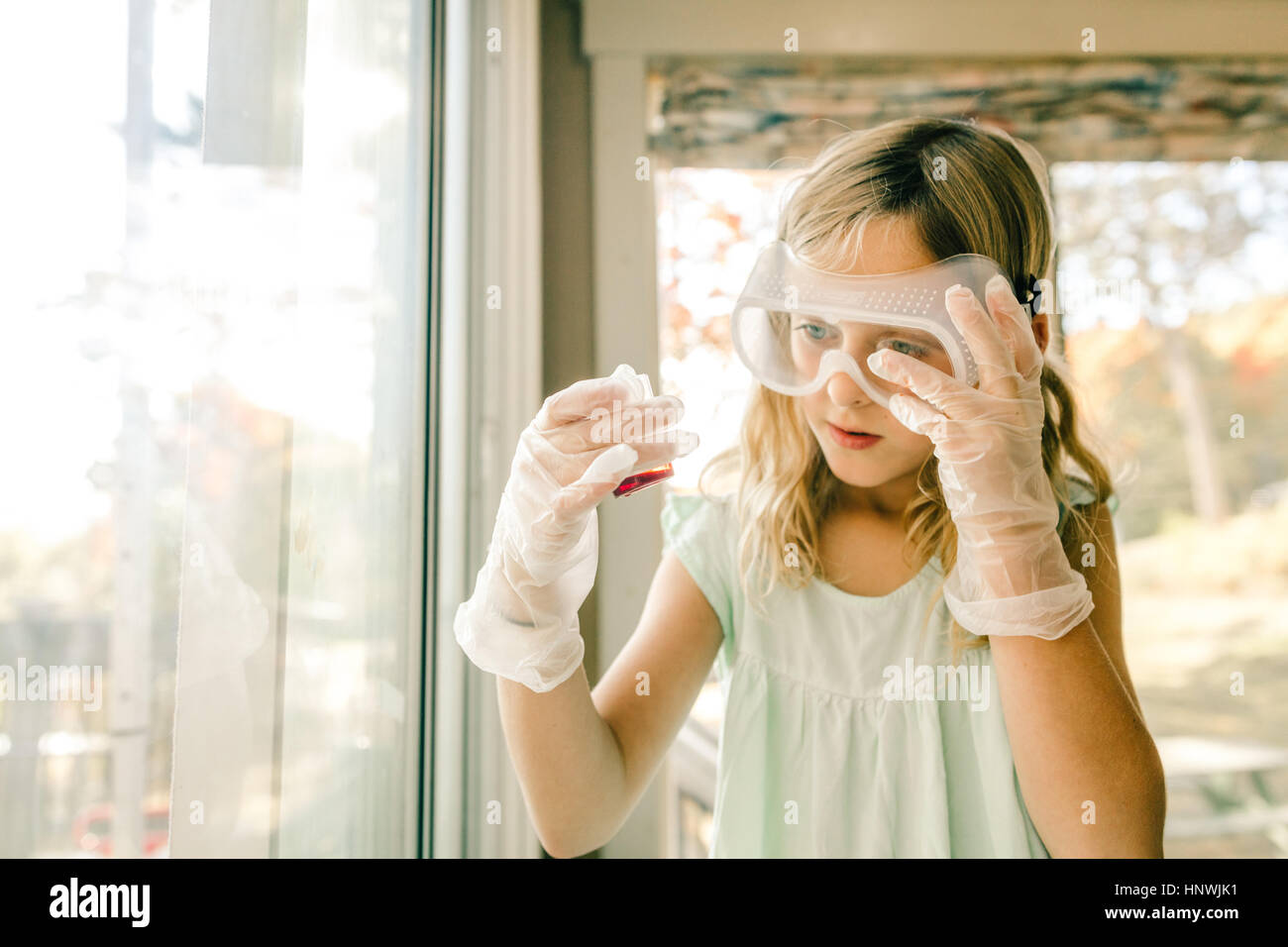 Girl doing science experiment, staring at measuring flask Stock Photo ...