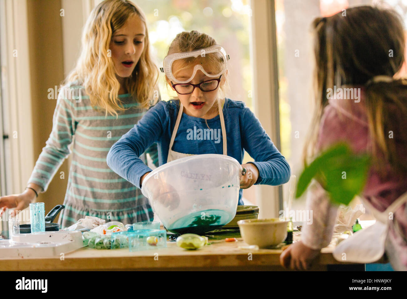Girls doing science experiment, mixing green liquid in bowl Stock Photo ...