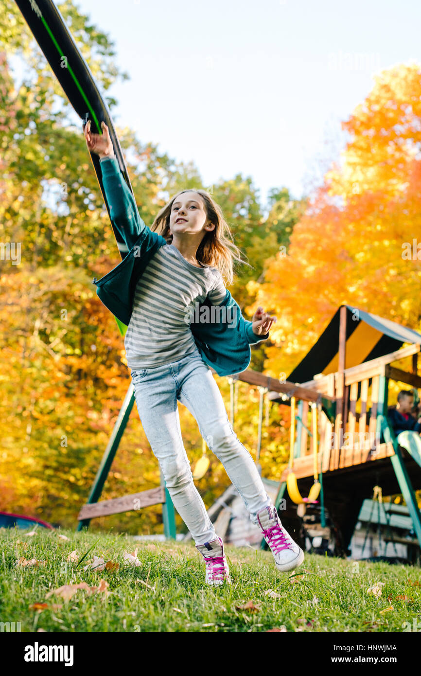 Girl jumping and throwing toy rocket in garden Stock Photo - Alamy