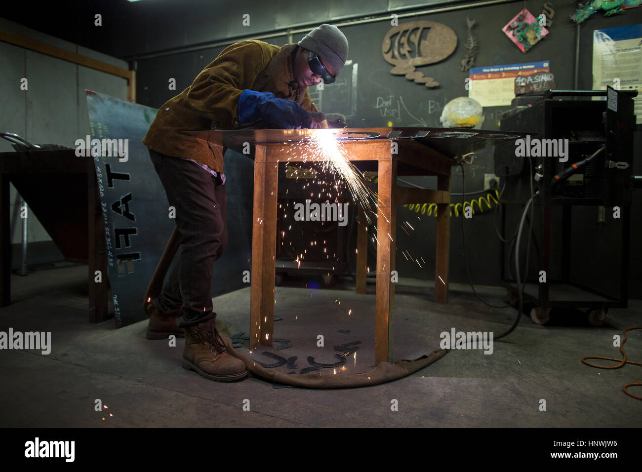 Male metalsmith plasma cutting metal at workbench Stock Photo - Alamy