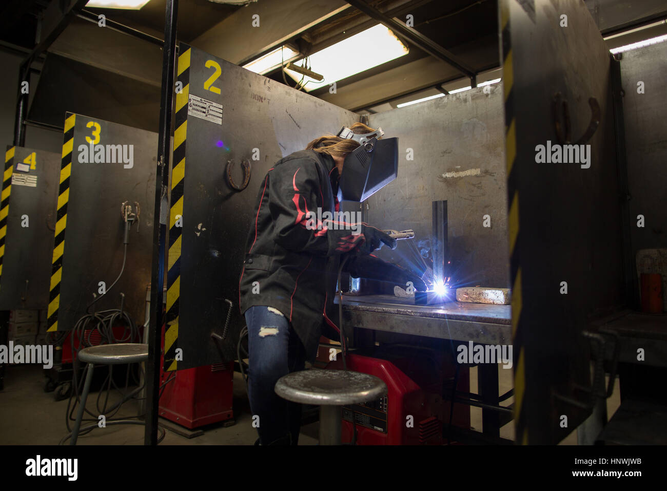 Female metalsmith welding metal at workbench Stock Photo - Alamy