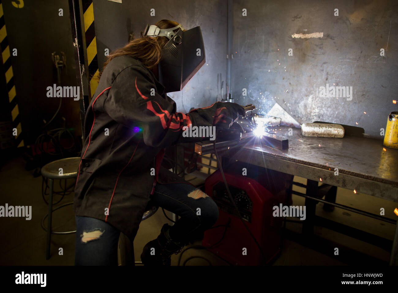 Female metalsmith welding metal at workbench Stock Photo - Alamy