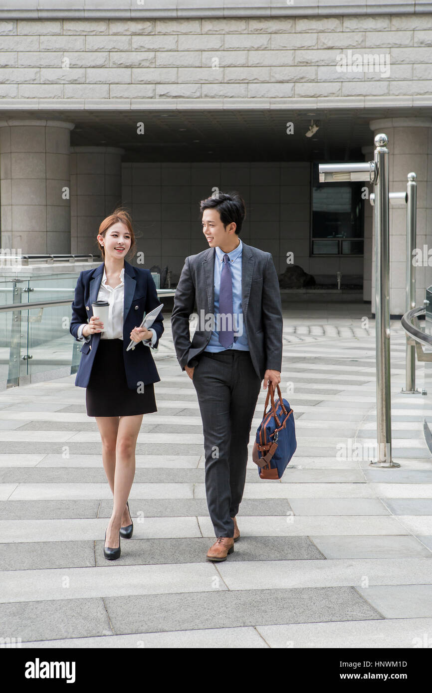 Smiling business people in suits walking Stock Photo - Alamy