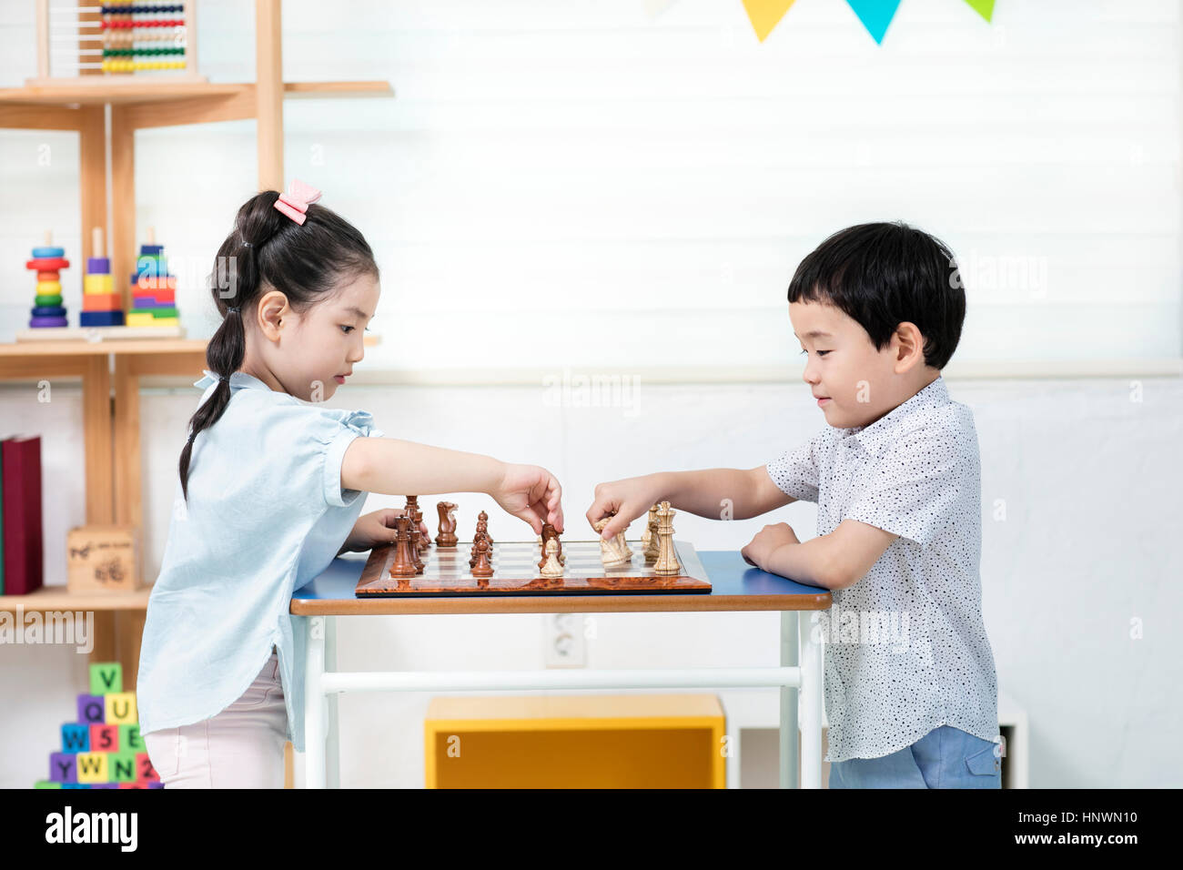 Kindergarten boy and girl playing board game Stock Photo - Alamy