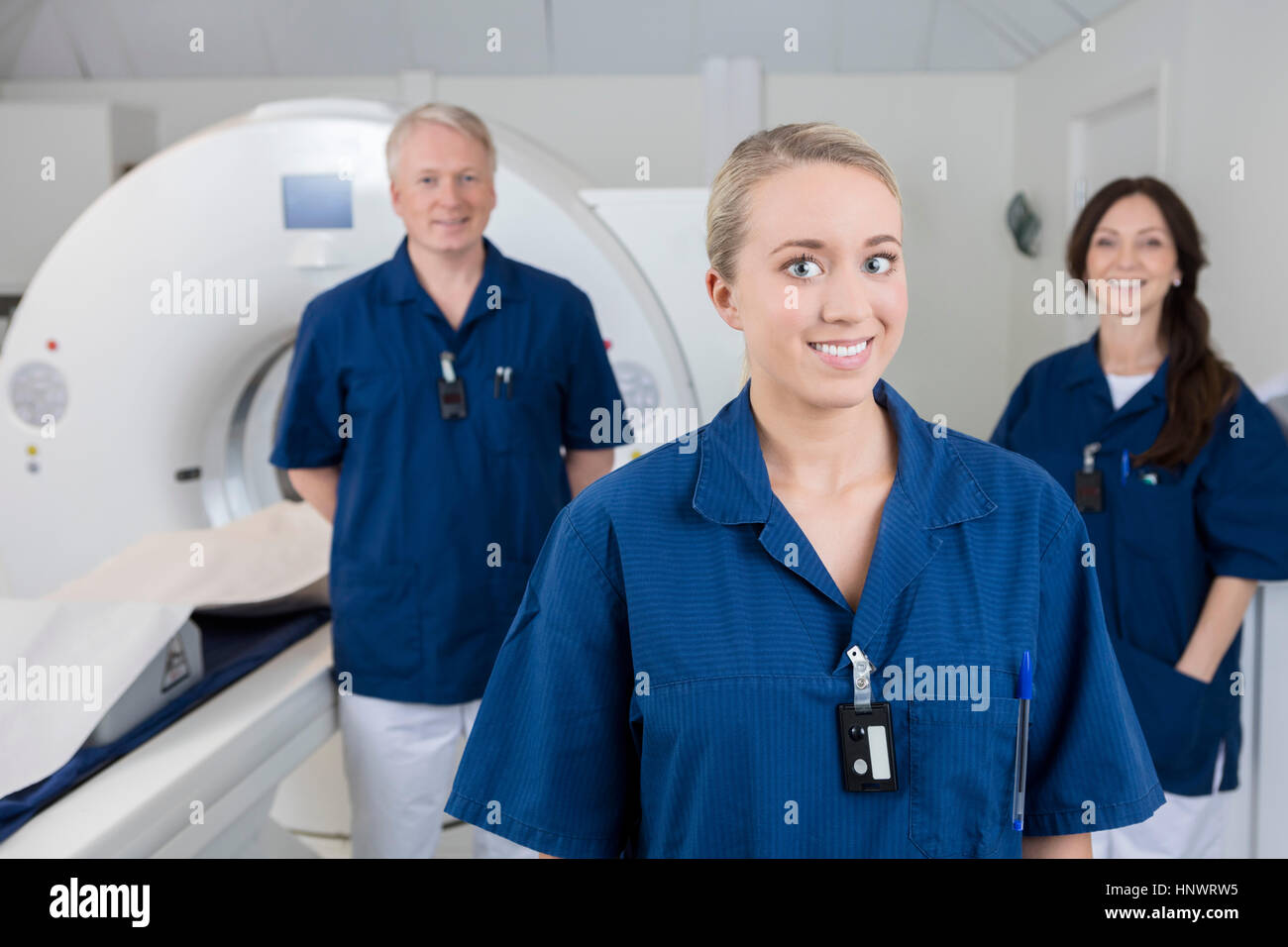 Smiling Medical Professional With Colleagues Standing By MRI Mac Stock ...