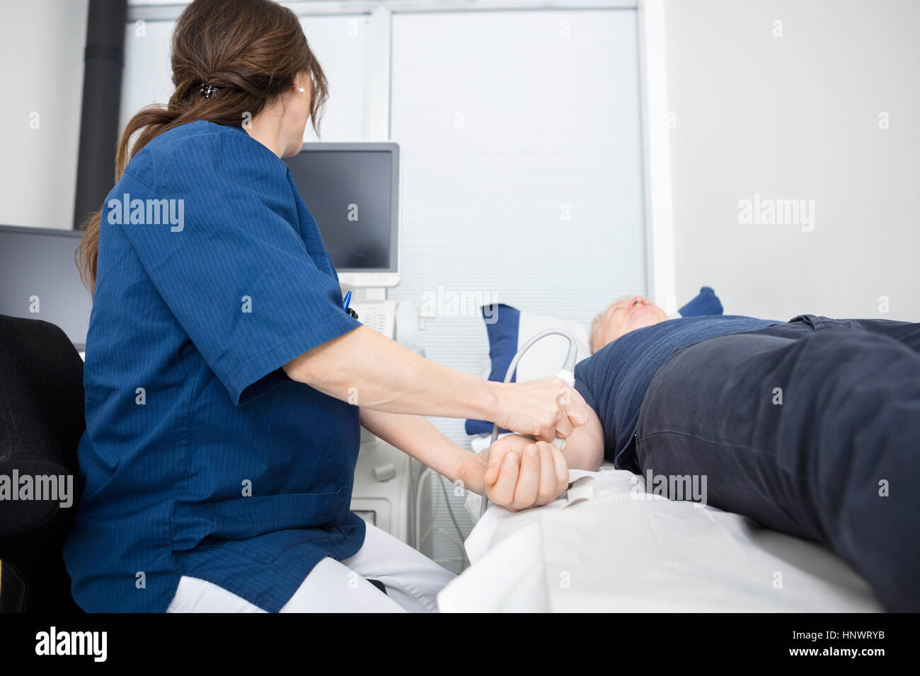 Doctor Using Ultrasound Probe On Male's Hand In Hospital Stock Photo ...