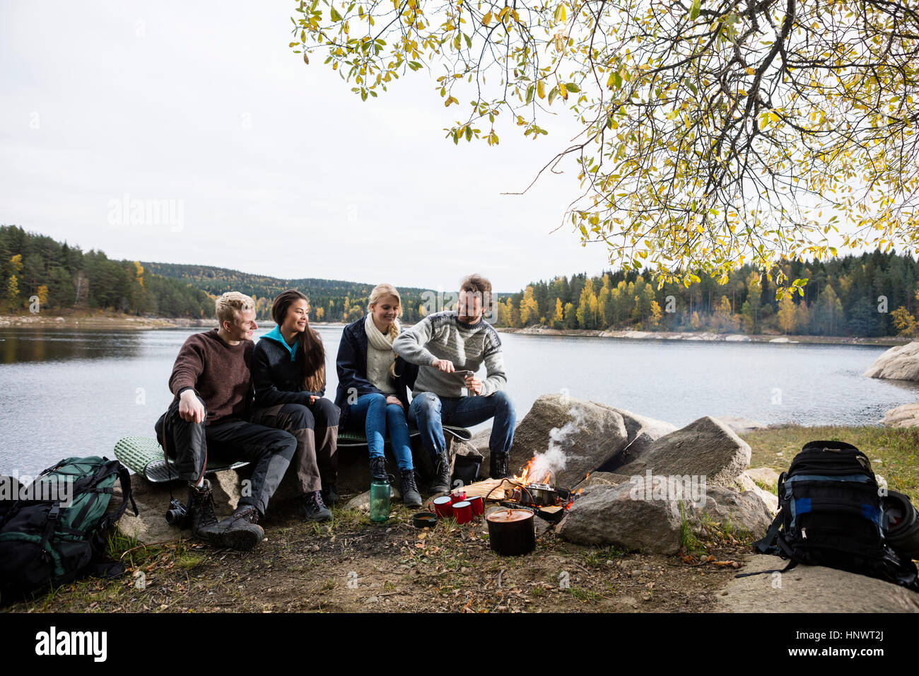 Happy Friends Camping On Lakeshore Stock Photo - Alamy