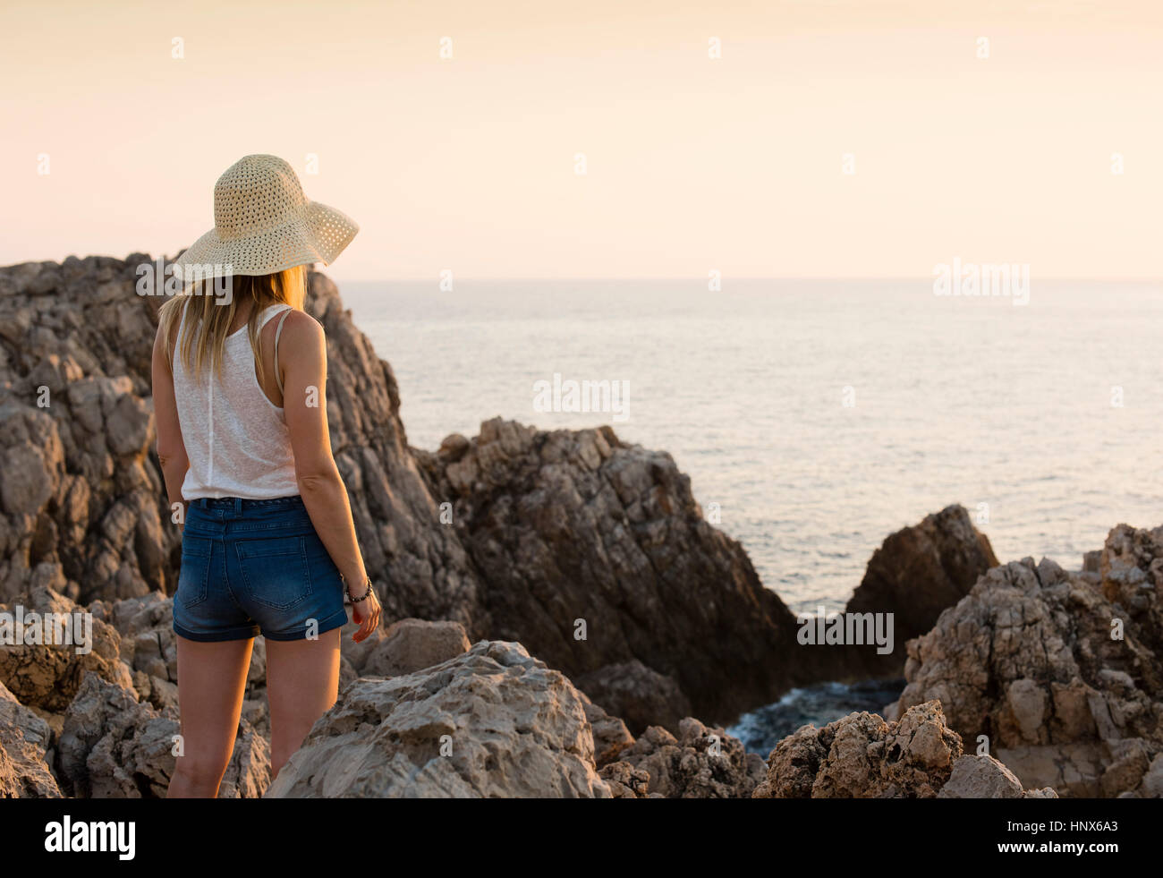 Rear view of woman looking at sea, Ciutadella, Menorca, Spain Stock ...