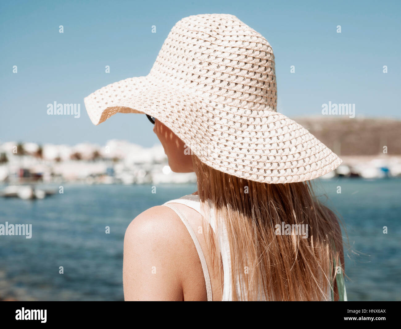 Rear view of woman wearing sun hat, Menorca, Spain Stock Photo - Alamy