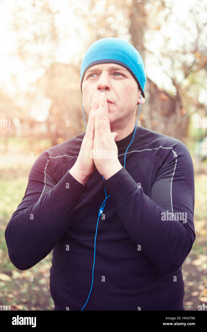 Mature man outdoors, wearing sports clothing, hands together Stock ...